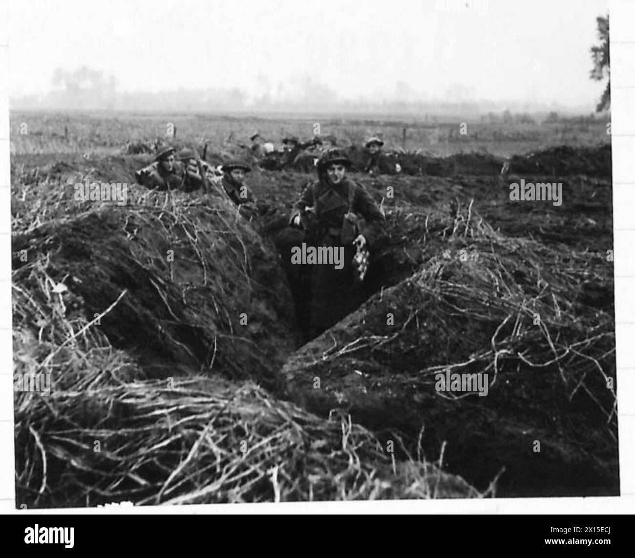 Infantry of the 1/5 Queen's move through a captured trench at Laar ...