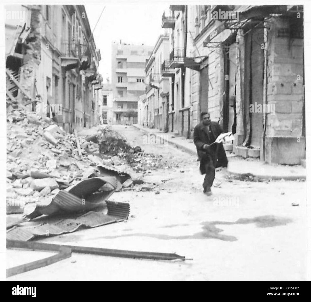 A Greek civilian in Athens uses a white flag to safely pass through a ...