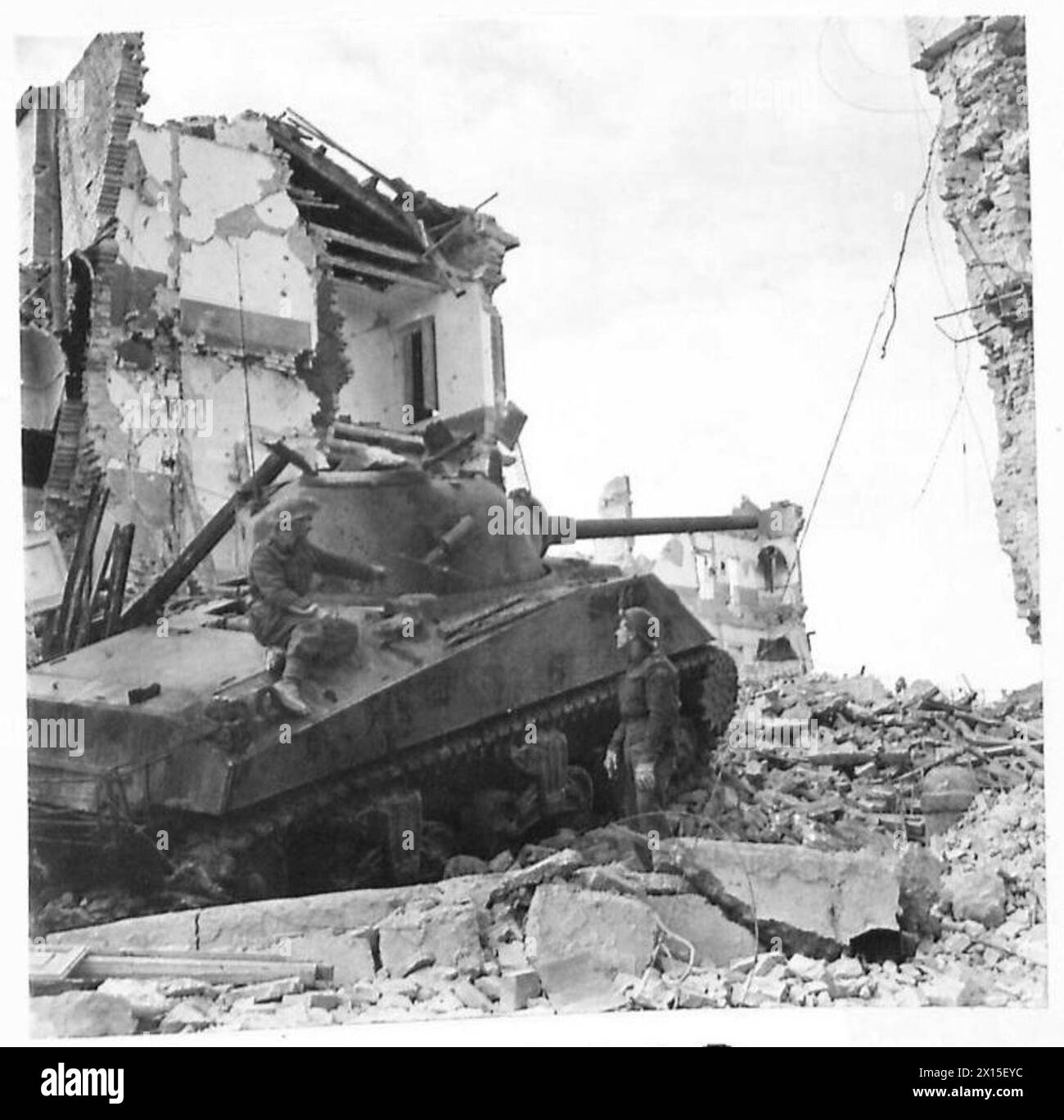 Pte. Dan Serjon and Cpl. Louis Cressman examine a destroyed Sherman ...