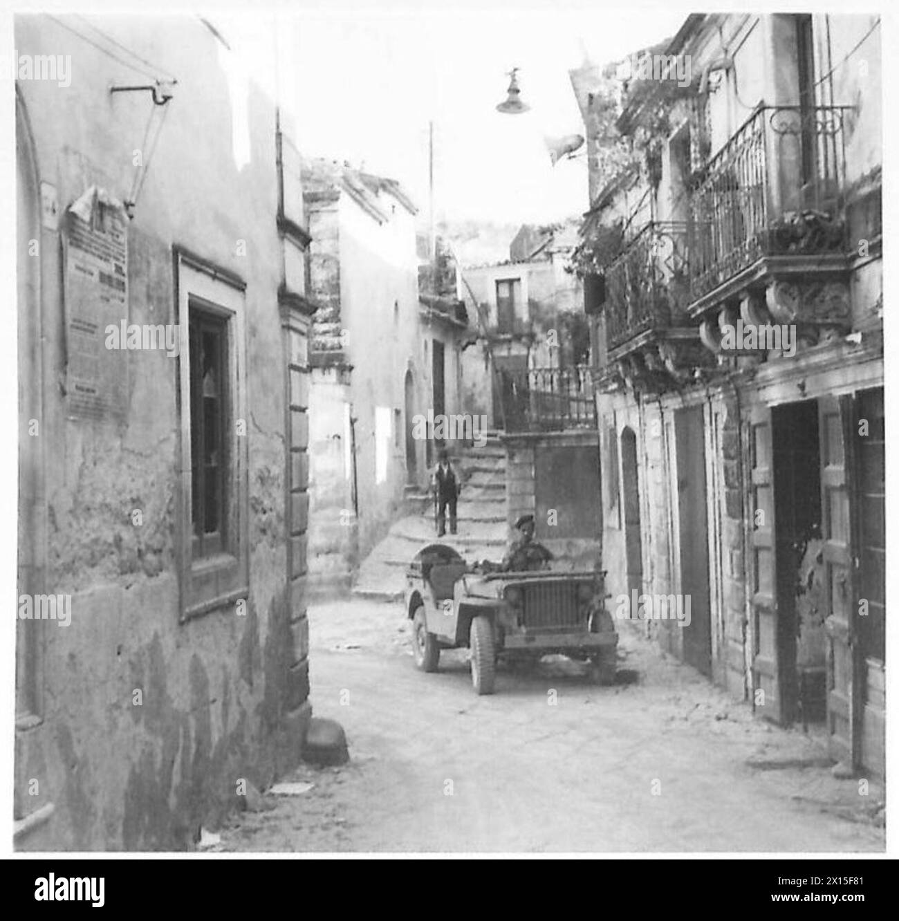 INVASION OF SICILY CAPTURE OF MELILLI - A Jeep driving through one of ...