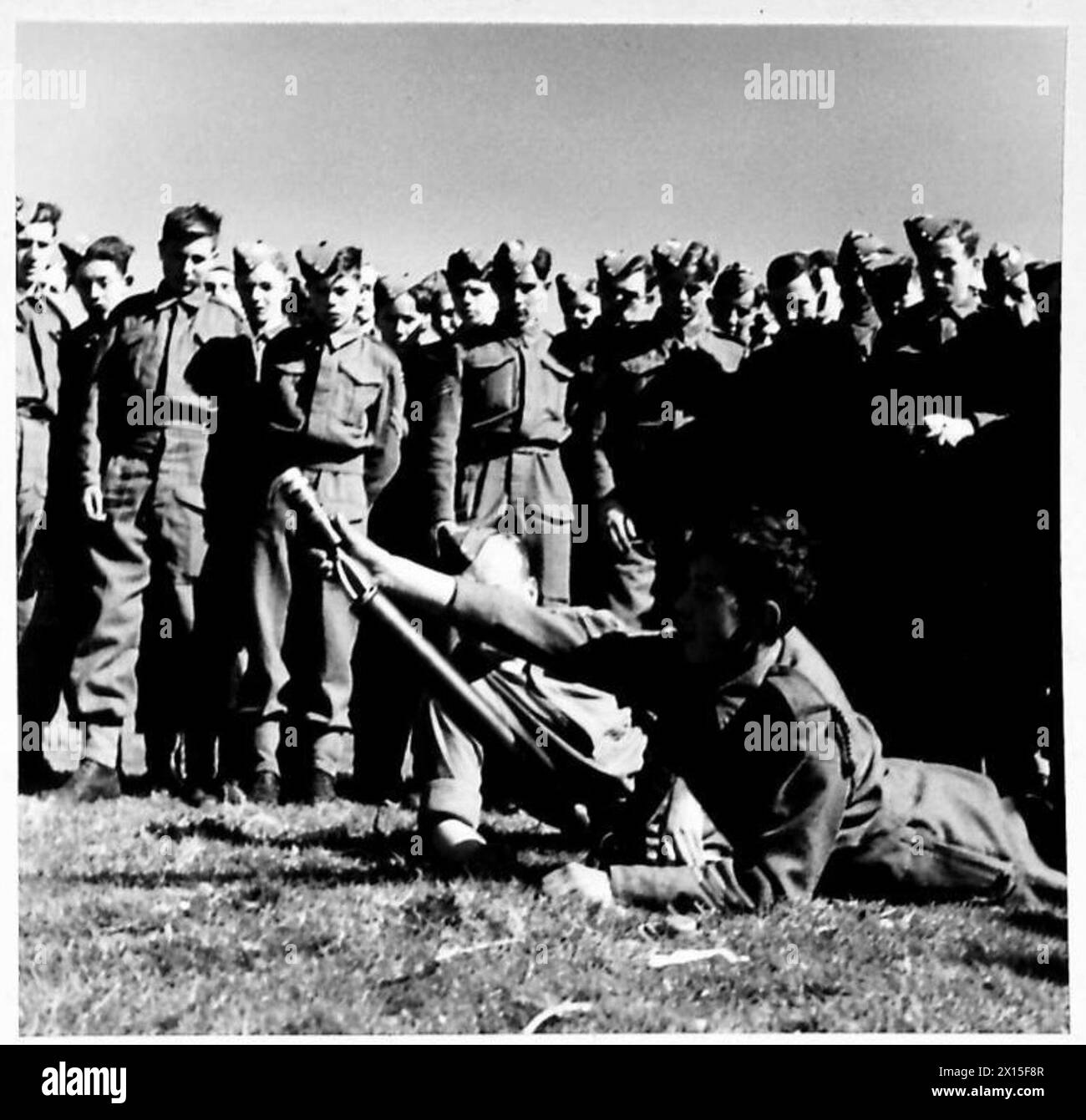 A Sergeant Major Instructor supervises young soldiers as one inserts a ...