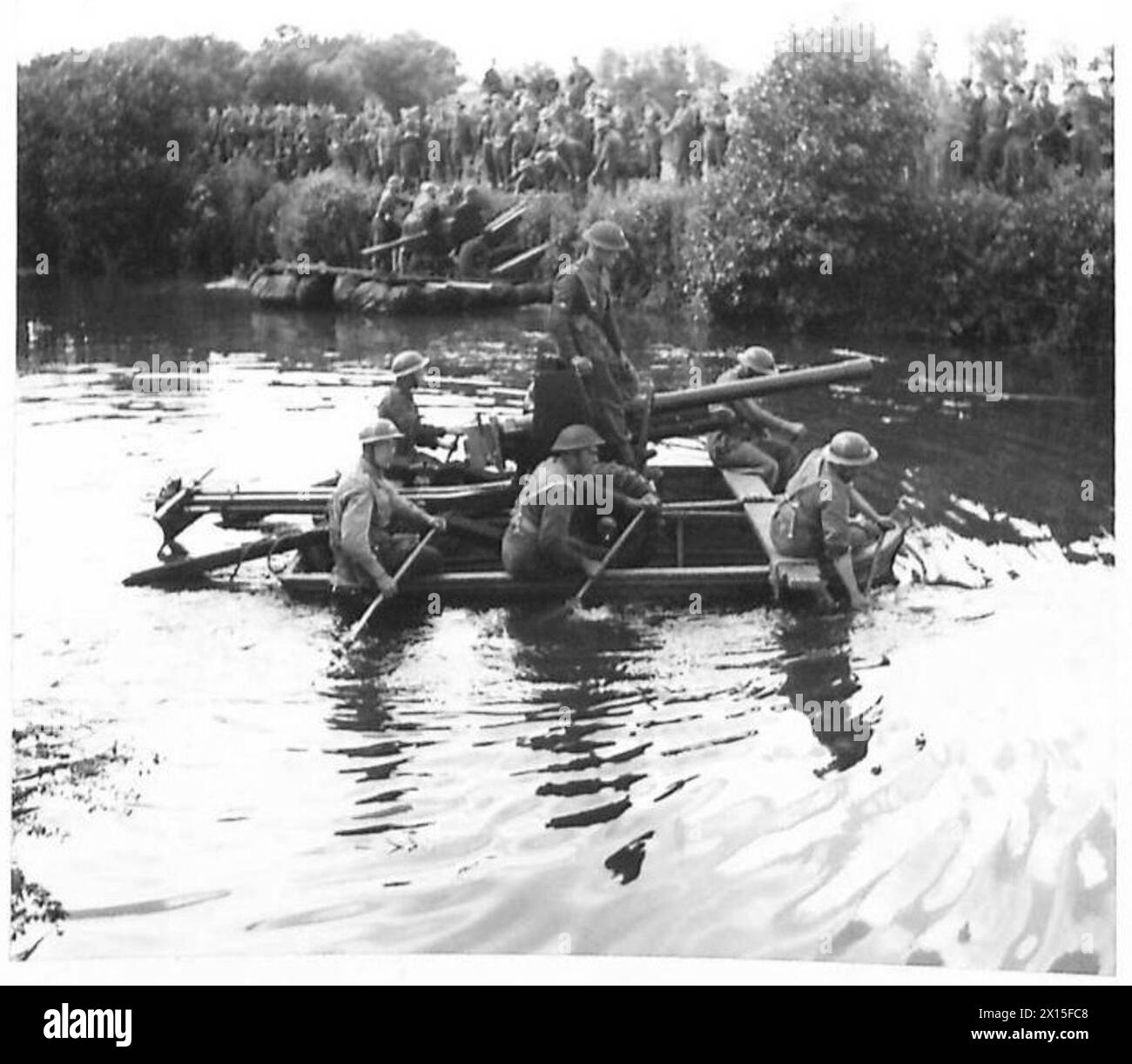 A 6-pounder anti-tank gun is transported across a river on an assault ...