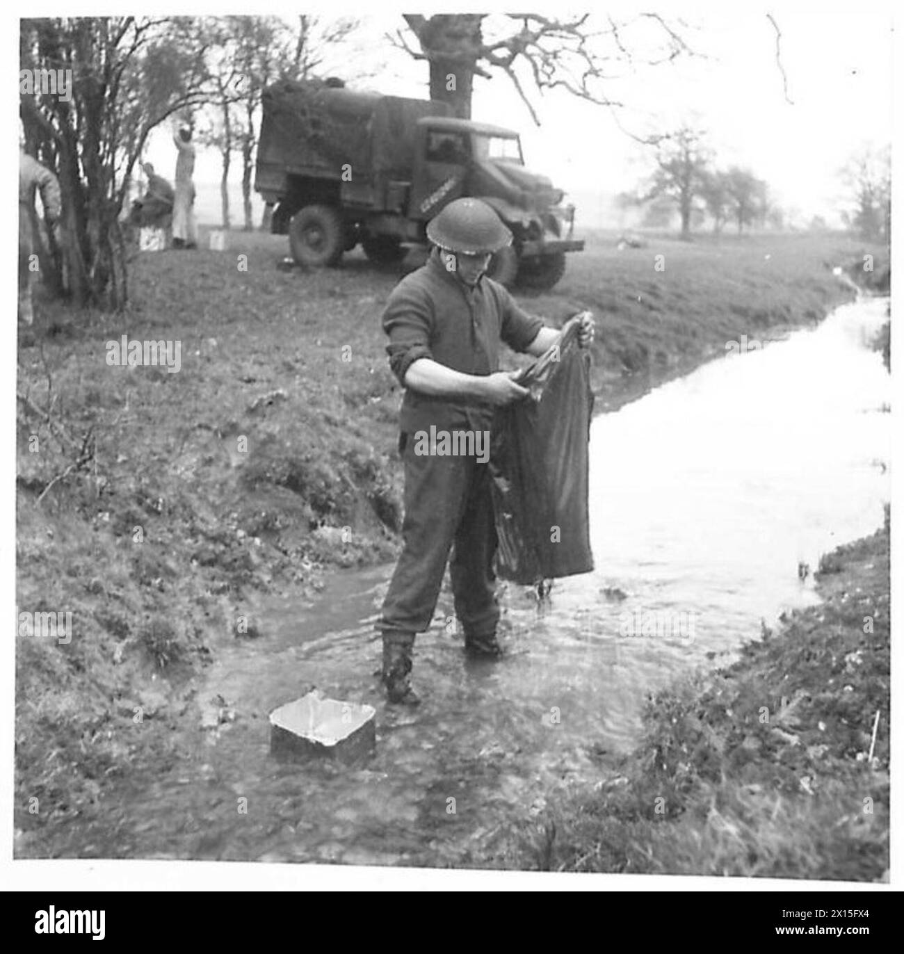 SPARTAN EXERCISE - A Canadian soldier washing his clothes in a stream ...