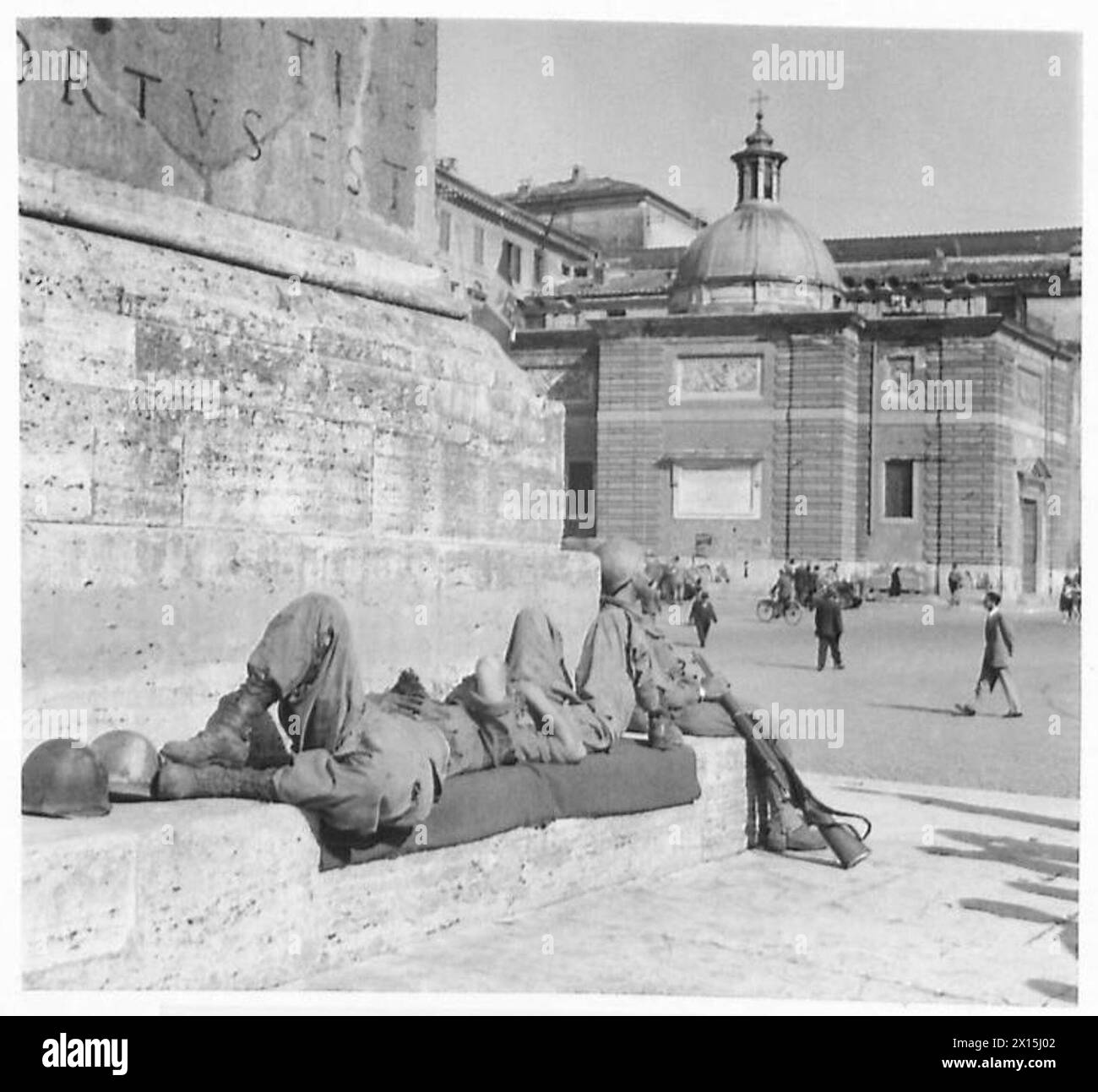 Allied soldiers of the British Army rest at the base of a monument in ...