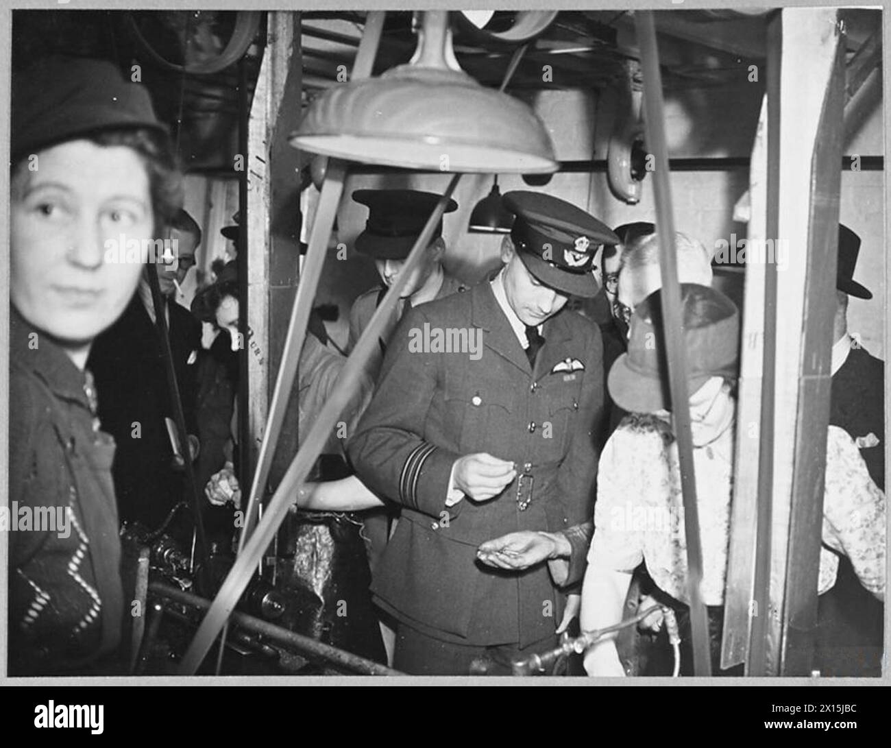 Squadron Leader J.D. Nettleton, V.C., observes female workers at a ...