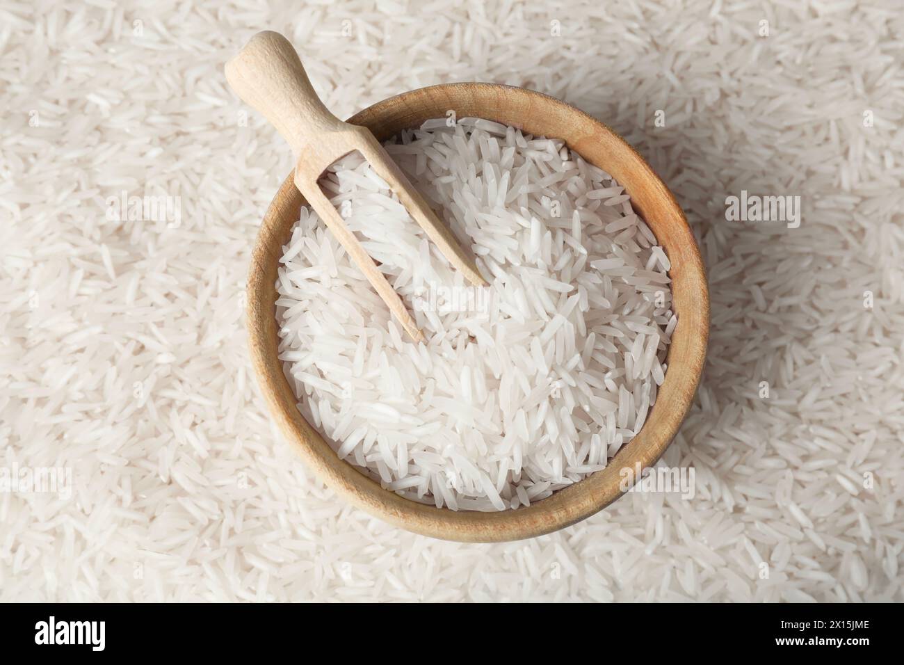 Raw basmati rice, bowl and scoop as background, top view Stock Photo ...