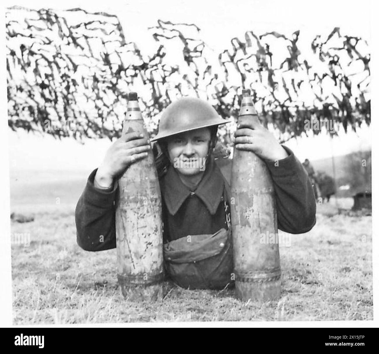 EXERCISES IN SCOTLAND - A gunner with a couple of six inch shells ...