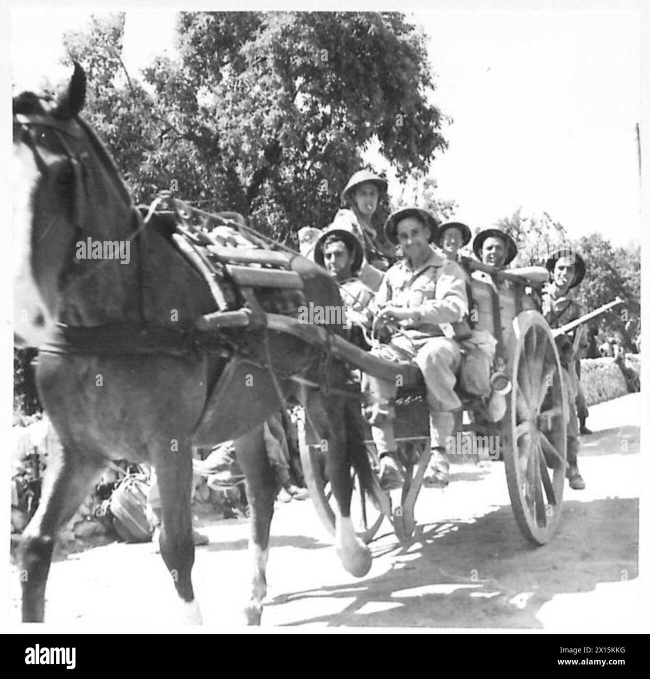 INVASION OF SICILY - Troops moving inland in a commandeered cart ...