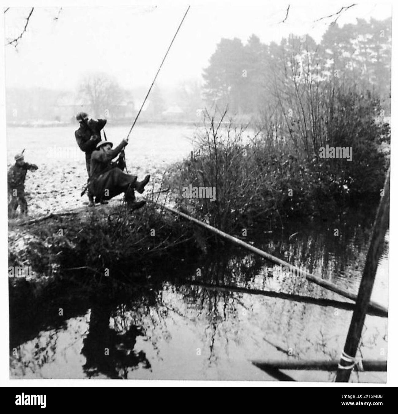 SCHOOL OF BATTLE DRILL - A soldier about to swing himself over a river ...