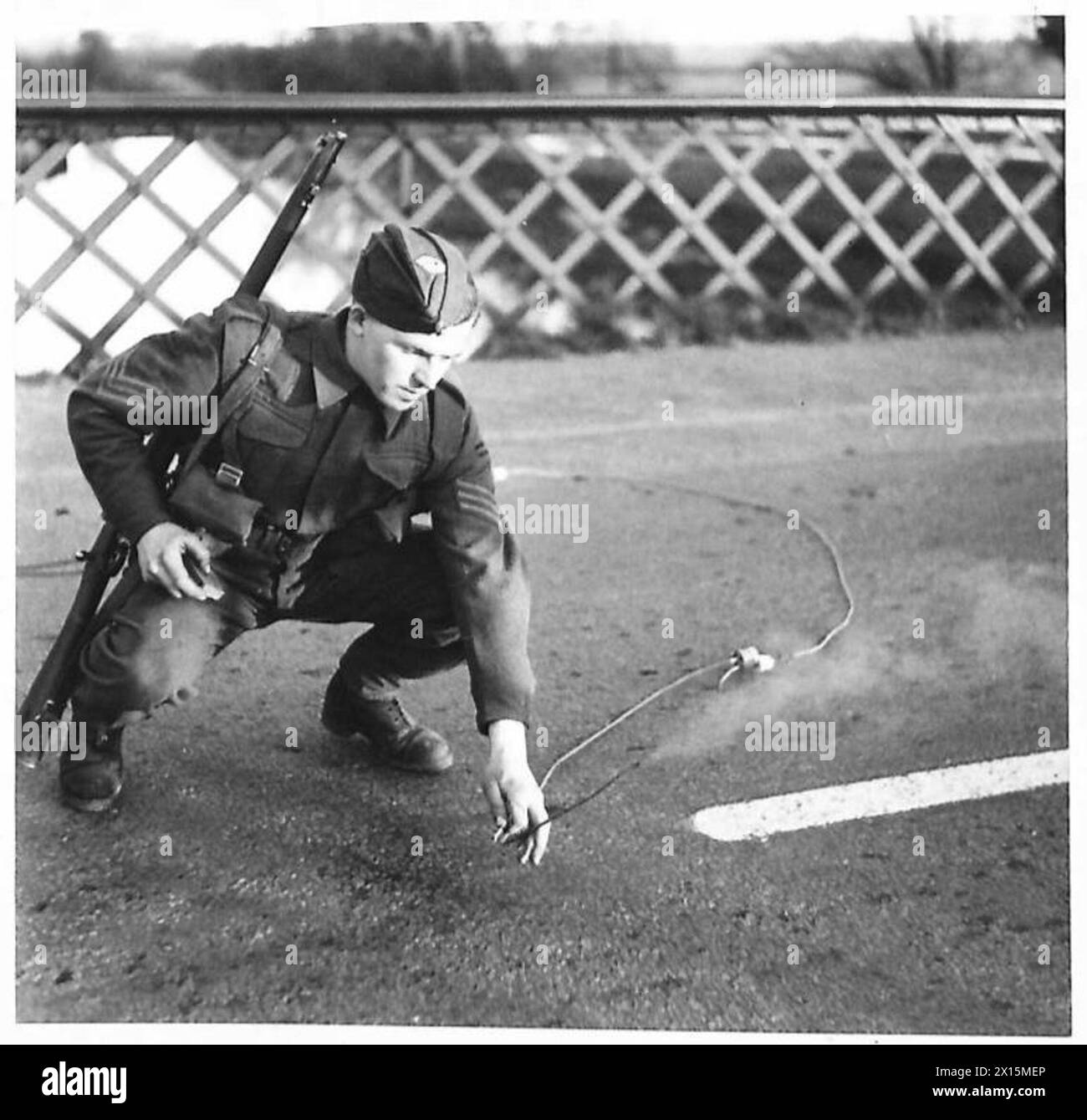 SPARTAN EXERCISE - An "Eastland" (German) soldier lighting a fuse to blow up a village to delay ...