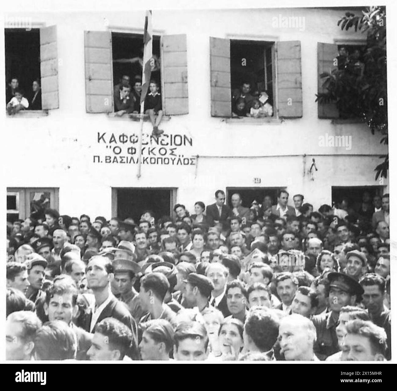 Citizens of Patras observe Allied troops moving through the town during ...