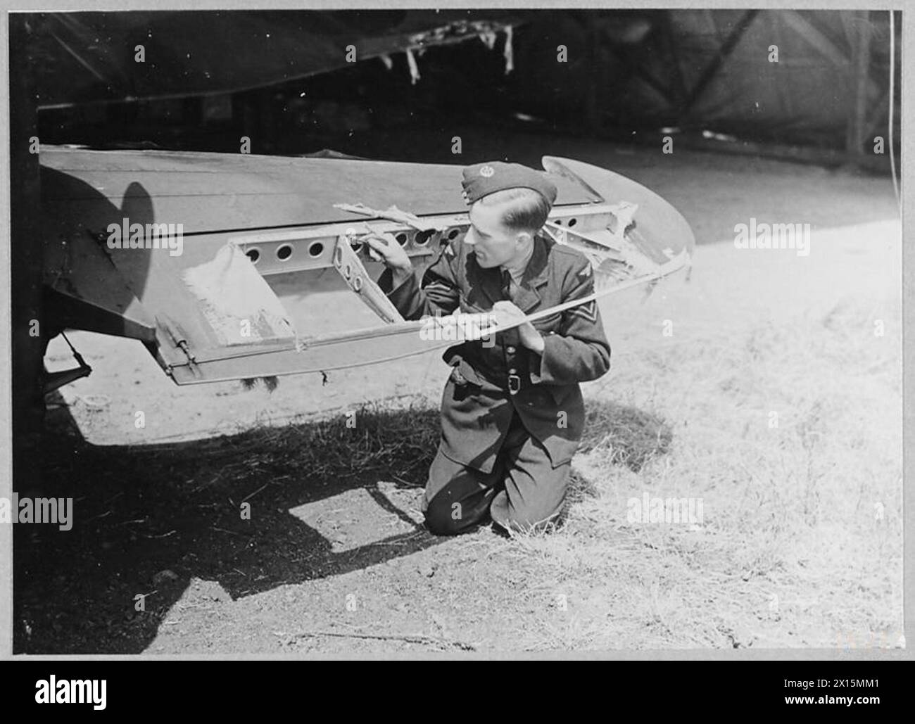 RAF FIGHTER COMMAND 1940 - An airman inspects damage to the tailplane ...