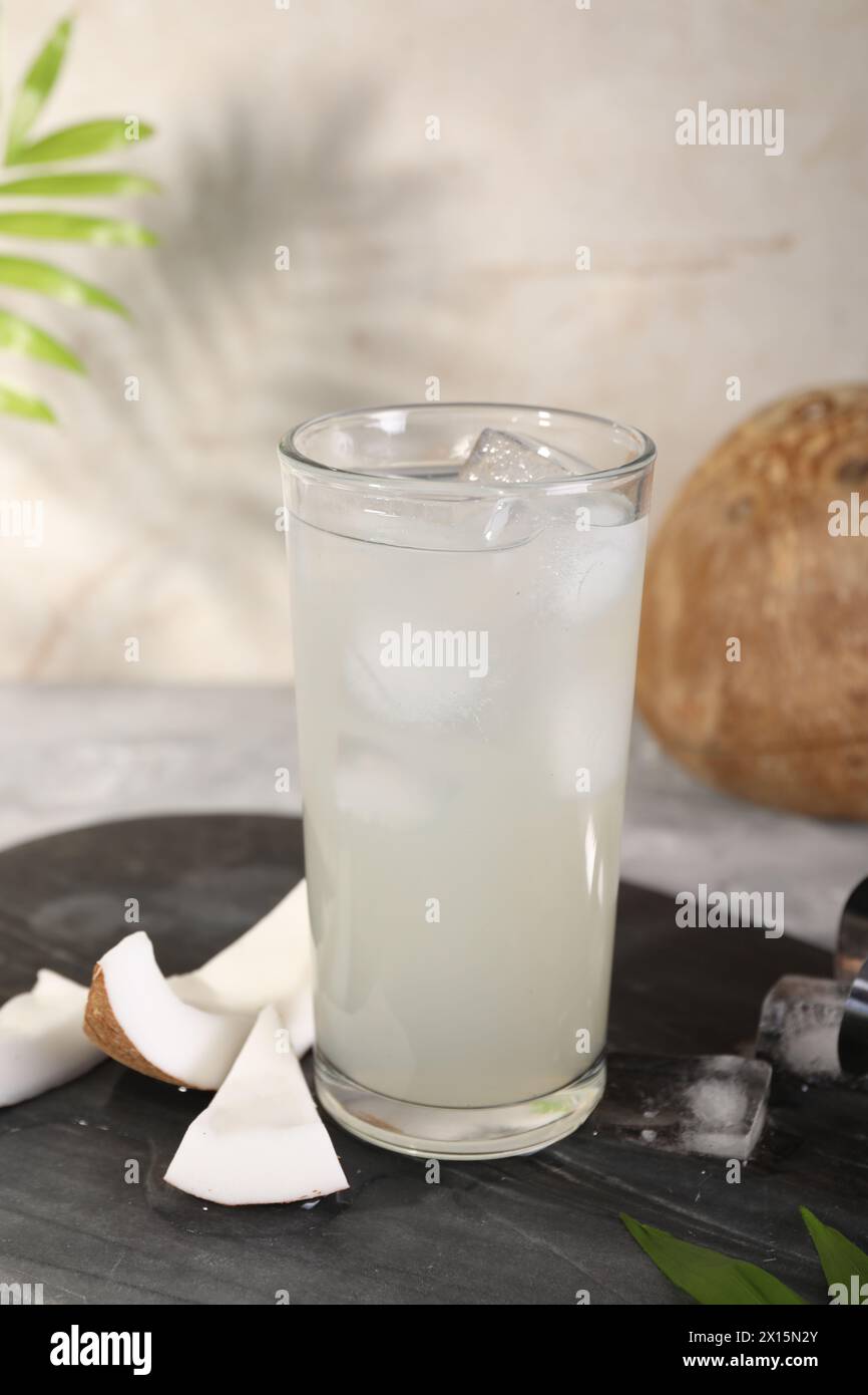 Glass of coconut water, ice cubes and nuts on table Stock Photo - Alamy