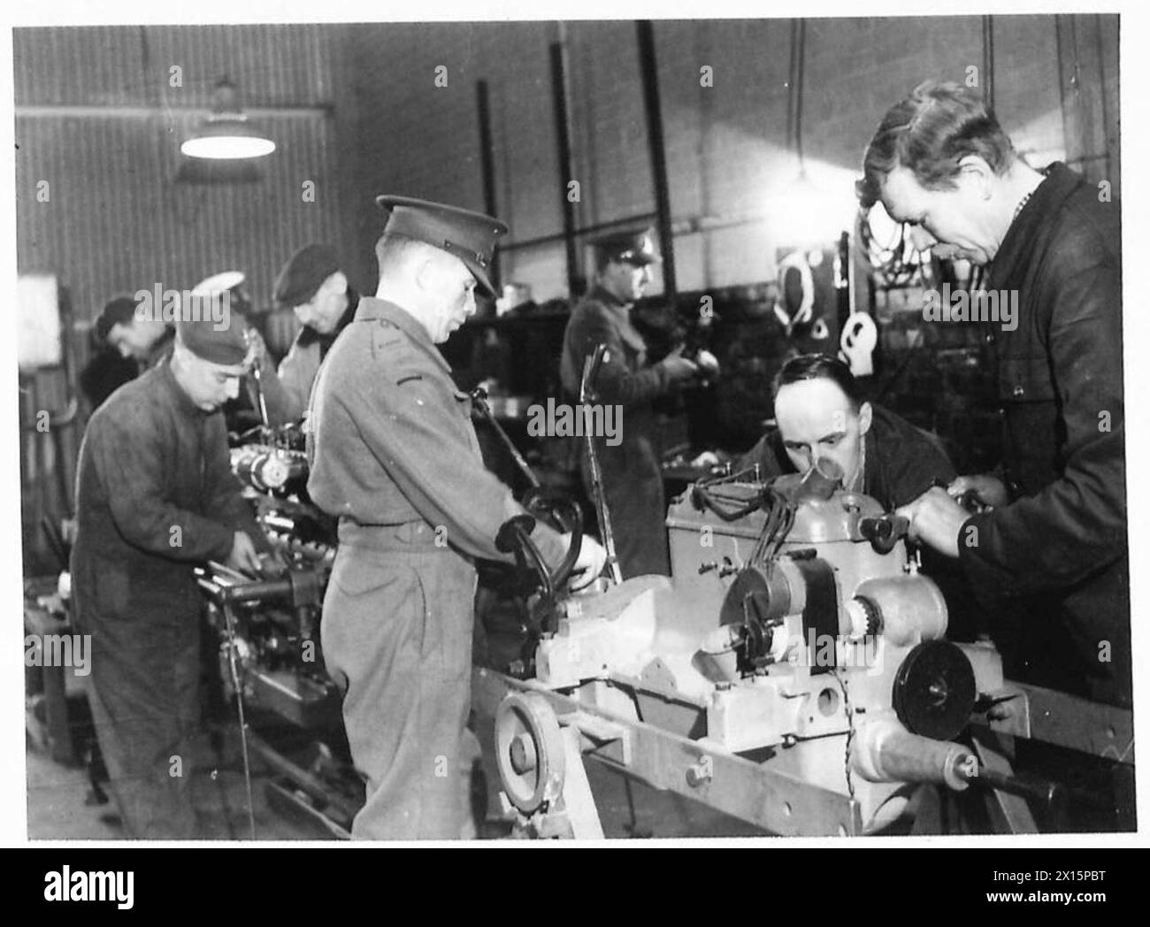 SOLDIERS AND CIVILIANS REPAIR ARMY EQUIPMENT - In the engine repair bay ...