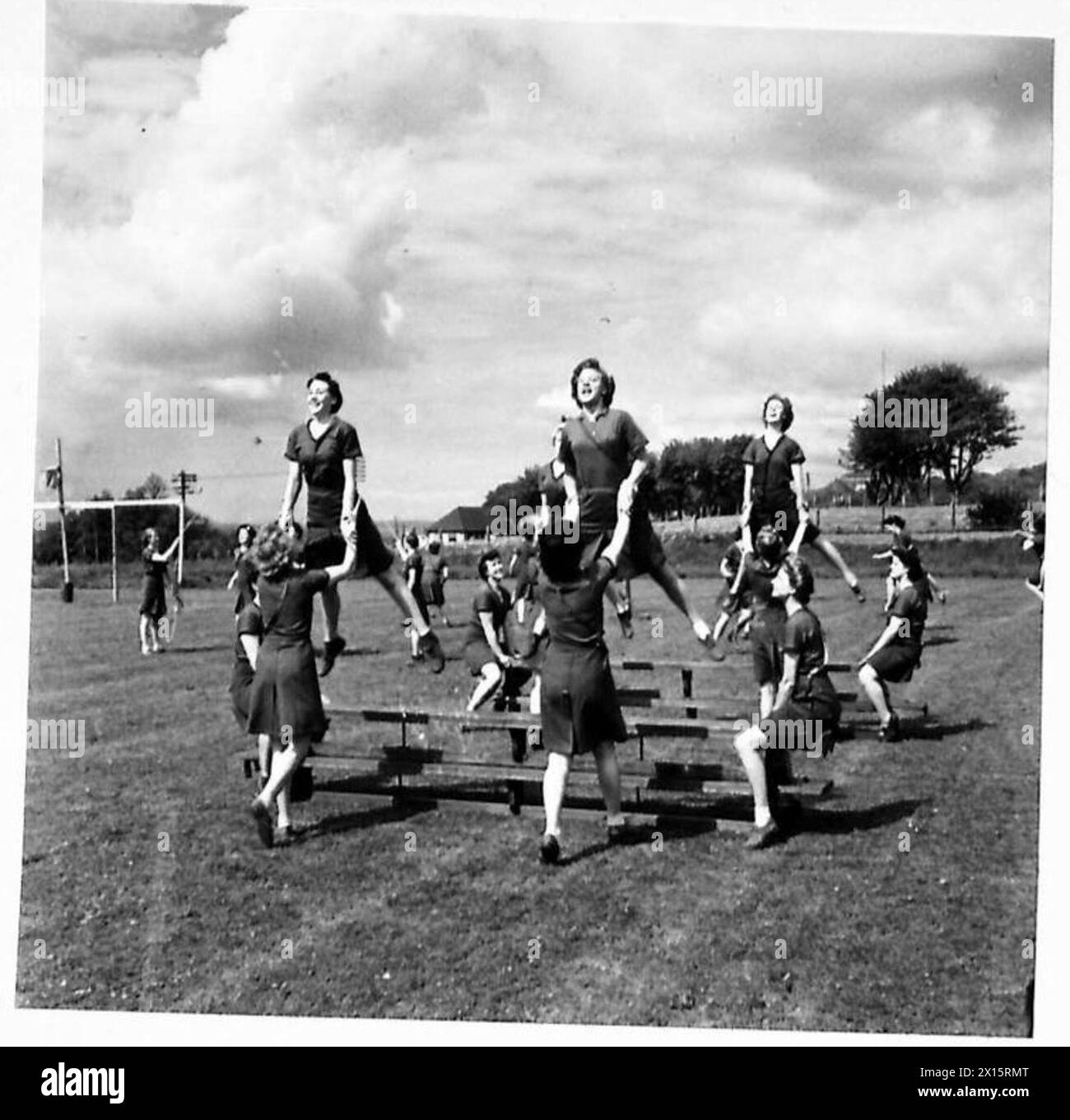 Female recruits at an ATS physical training school performing leaping ...