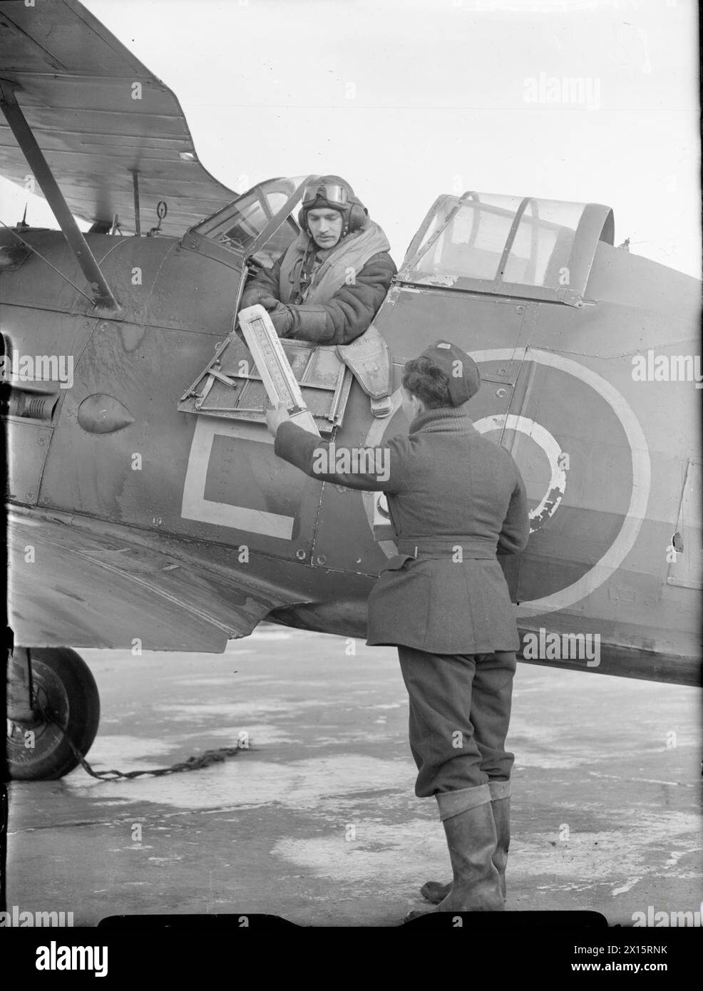Flying Officer J.B. Gordon of No. 521 Squadron RAF receives a ...