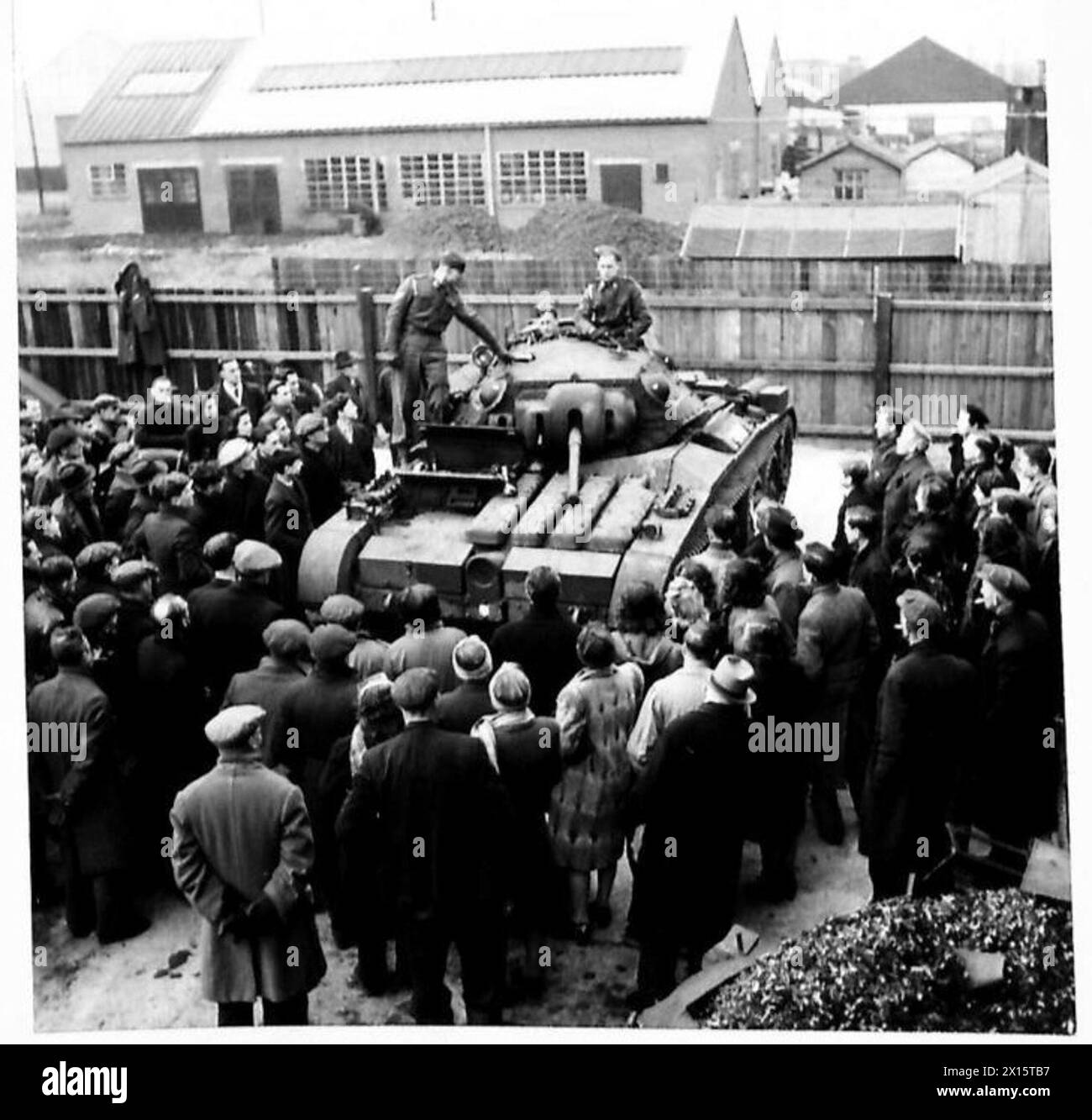 FACTORY WORKERS SEE THE FINISHED ARTICLE - Workers crowd round a ...
