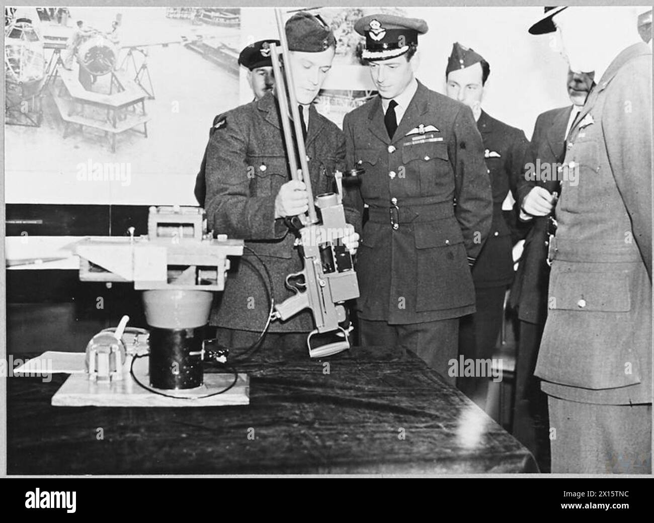 An airman demonstrates the operation of a camera gun to the Duke during ...