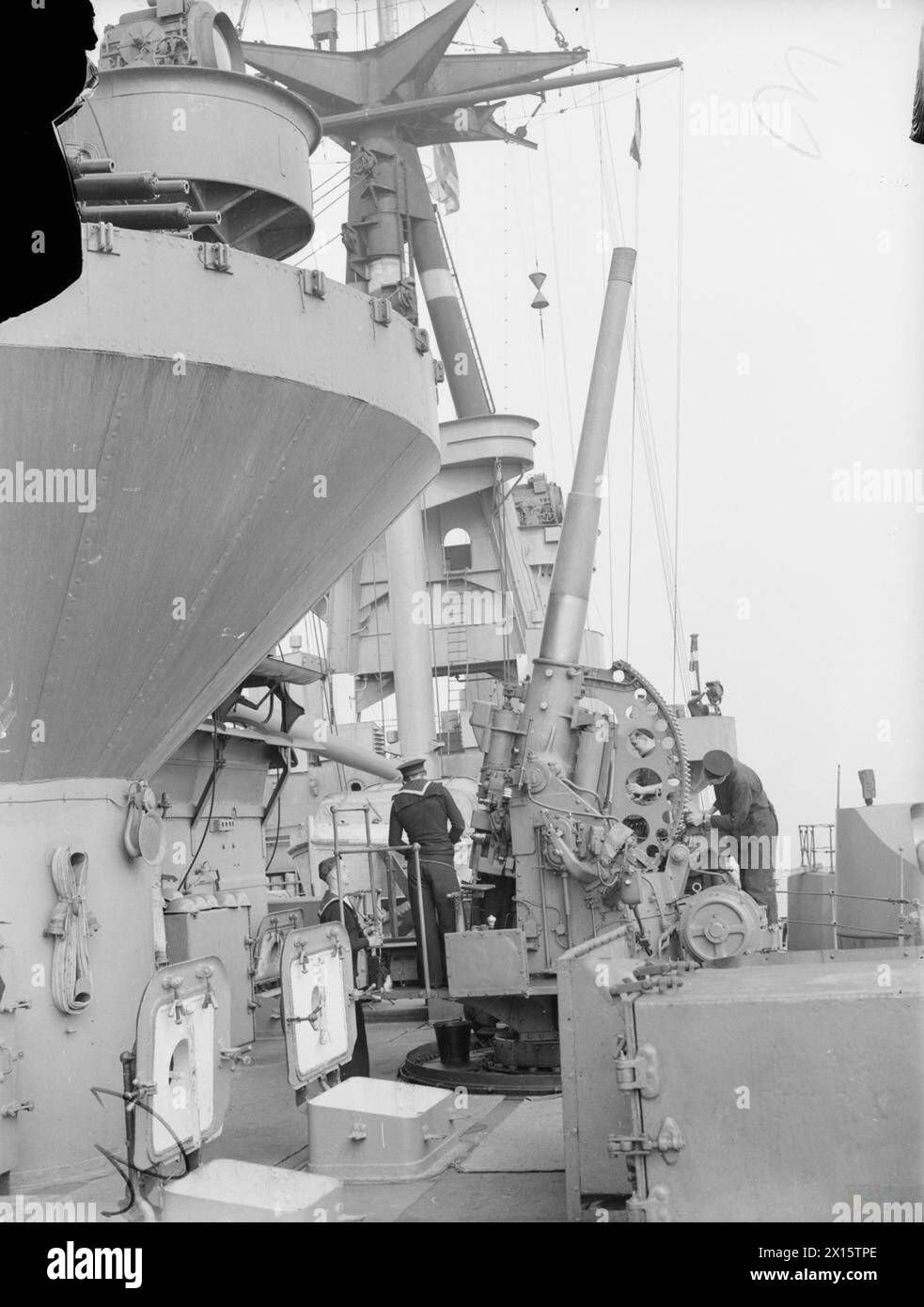 Crew members aboard the battleship HMS Rodney clean a 4.7-inch naval ...