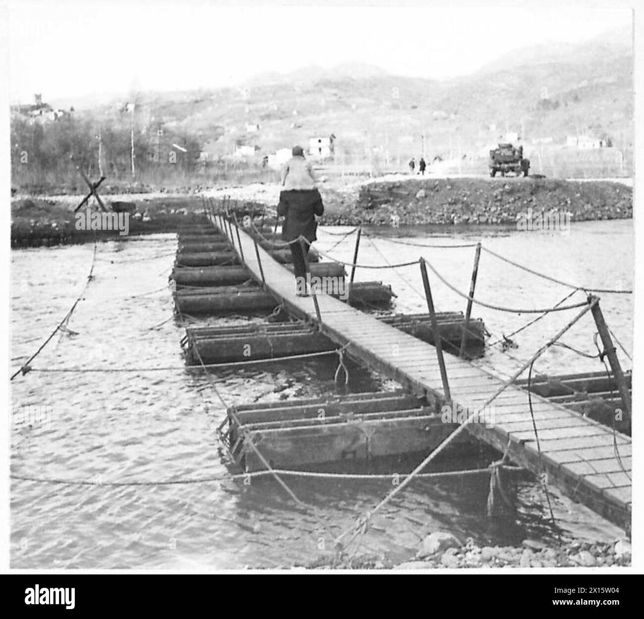 An Italian civilian and a child cross a river in the Serchio Valley ...