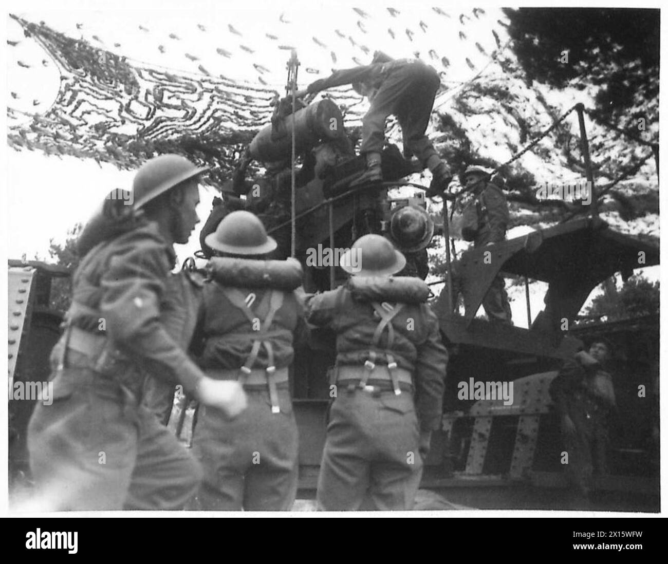 An artillery shell is lifted and positioned onto a loading cradle ...