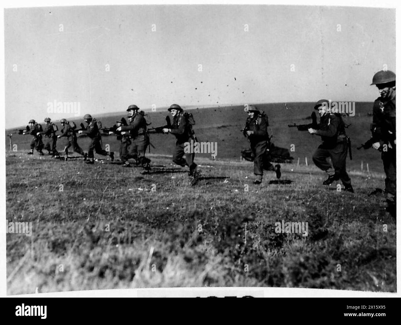 Soldiers advance at the double while firing Bren guns from the hip ...