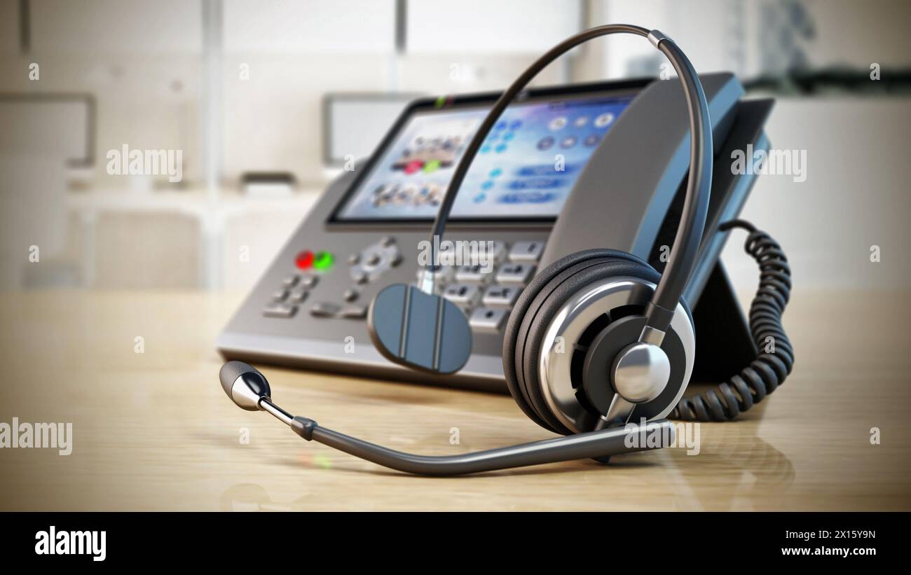 Modern VoIP phone and headset standing on wooden office table. Call ...