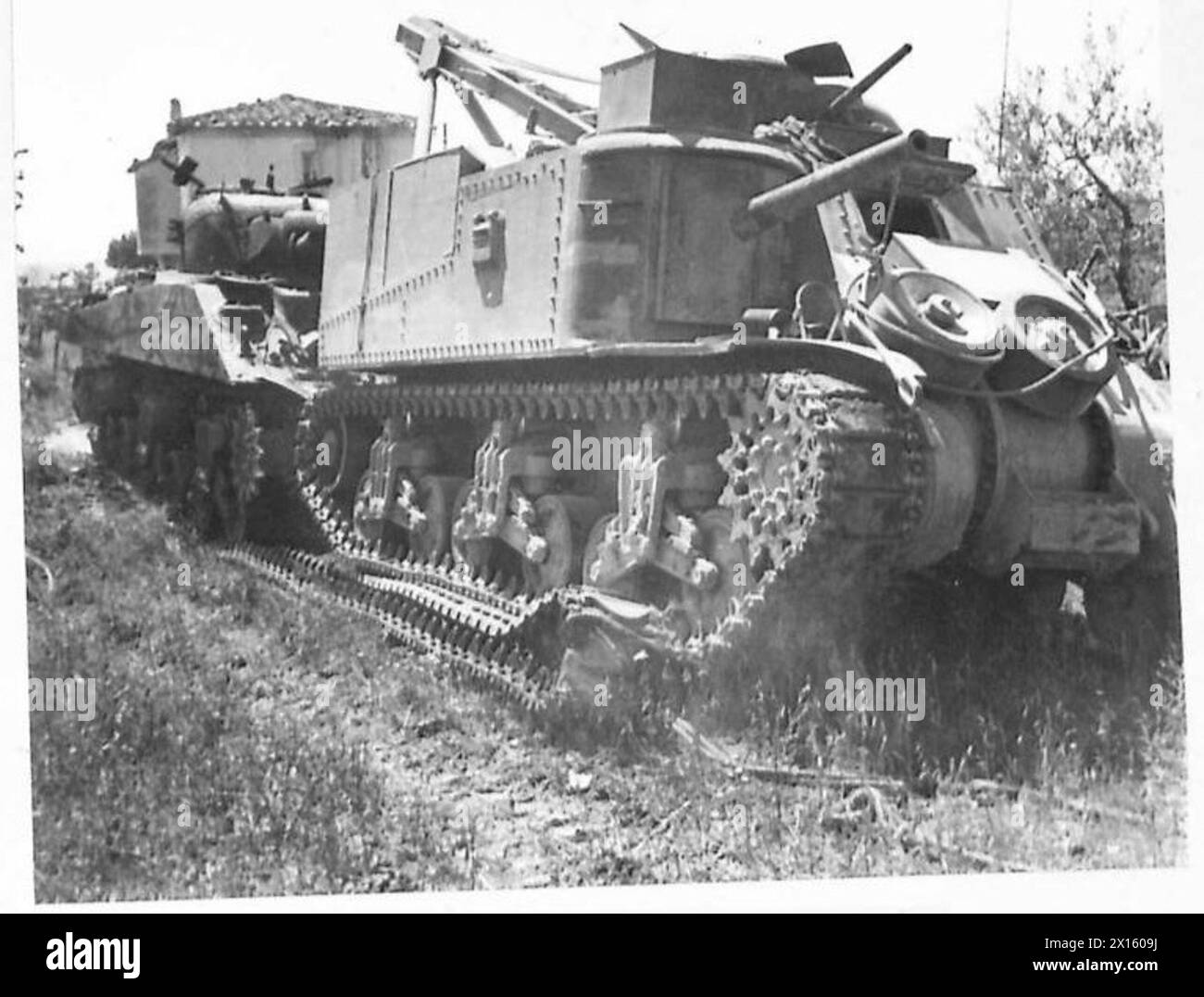 EIGHTH ARMY : VARIOUS - A knocked-out Sherman tank is brought in by a ...