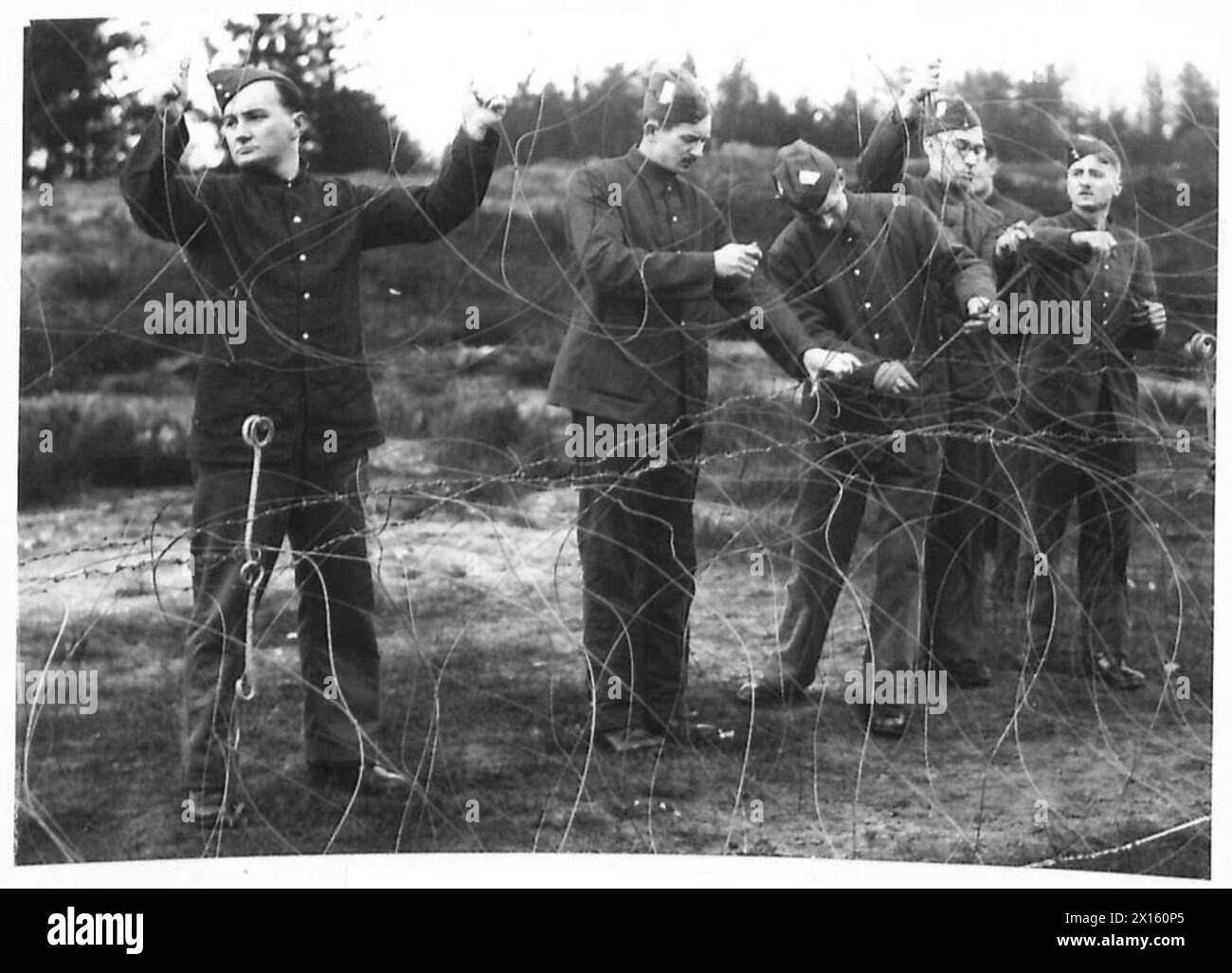Cadets at Camberley train by erecting triple concertina wire obstacles ...