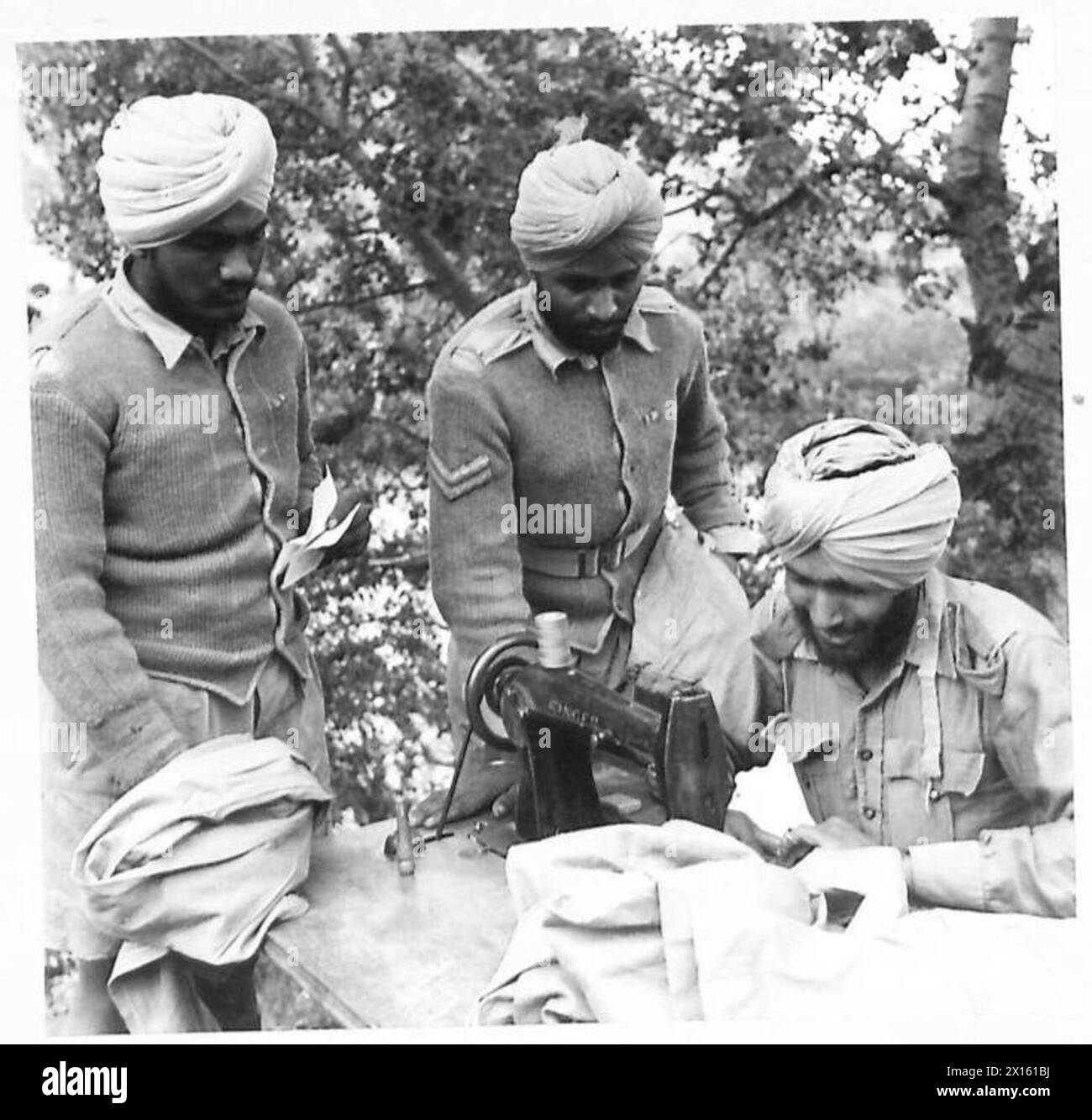 INDIAN TROOPS WITH THE 8TH ARMY - The Sikh tailor is quite busy making ...
