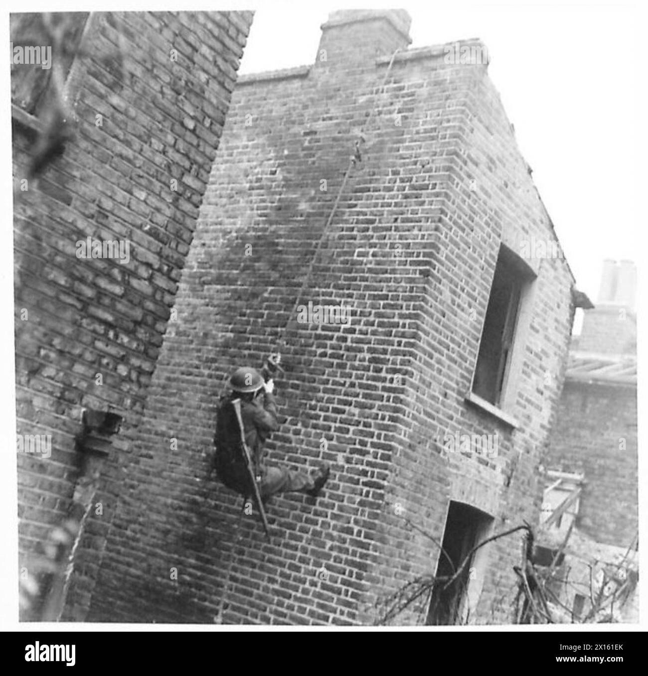 A trainee from the Army Physical Training Corps demonstrates scaling ...