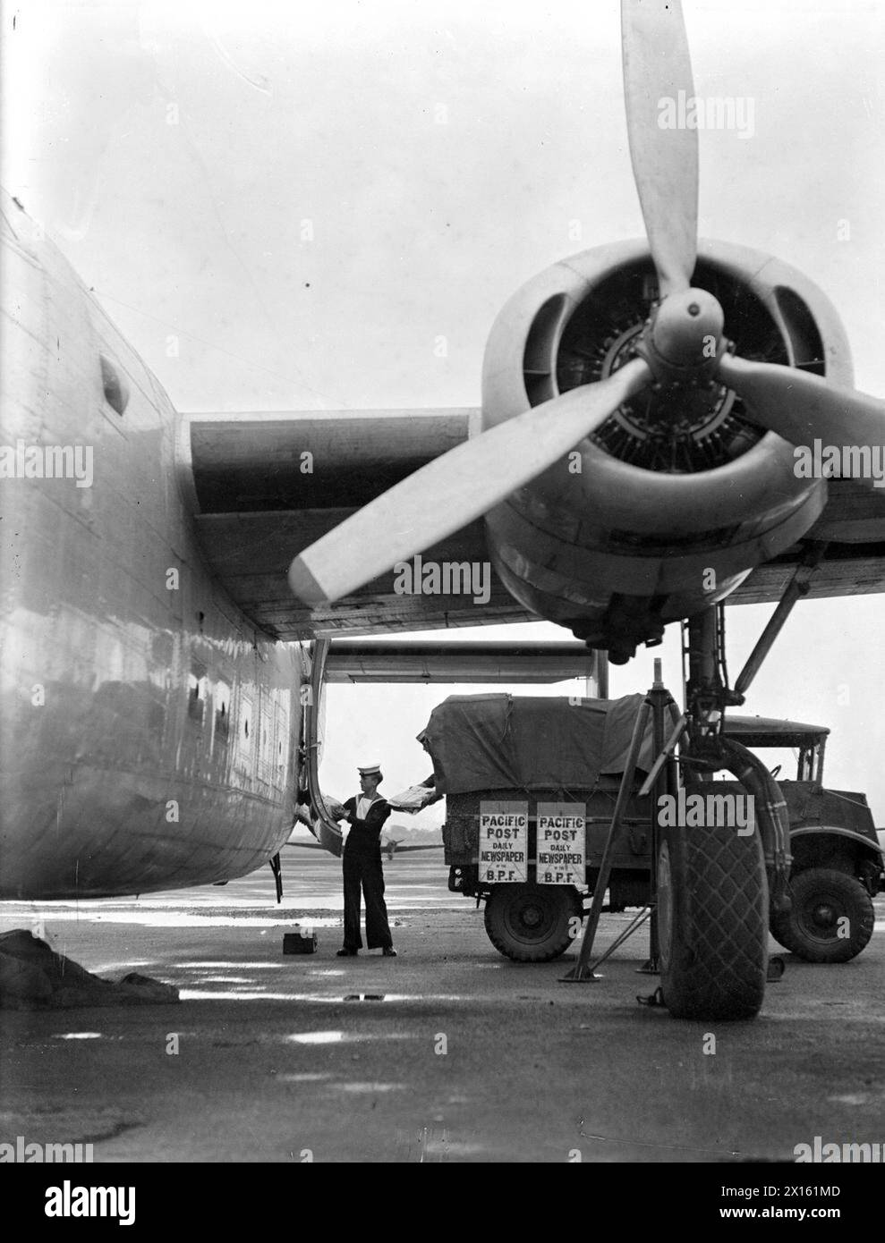 Able Seaman Sam Meadows of London loads the 'Pacific Post' newspaper ...