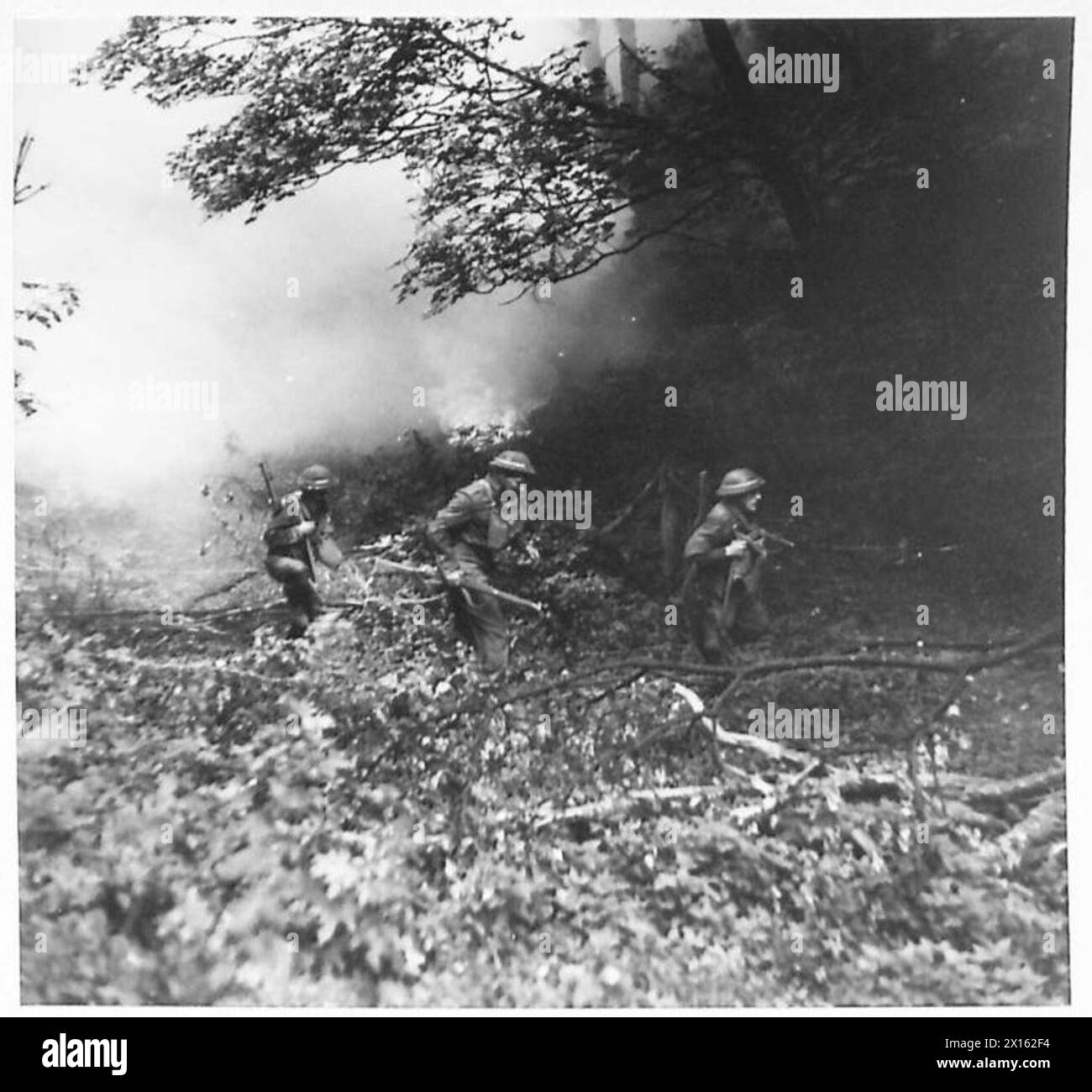 Military Police personnel crossed a stream and moved through a wooded ...