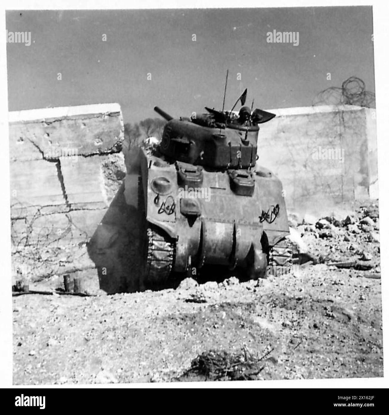 A Sherman tank of the 79th Armoured Division passes through a wall ...