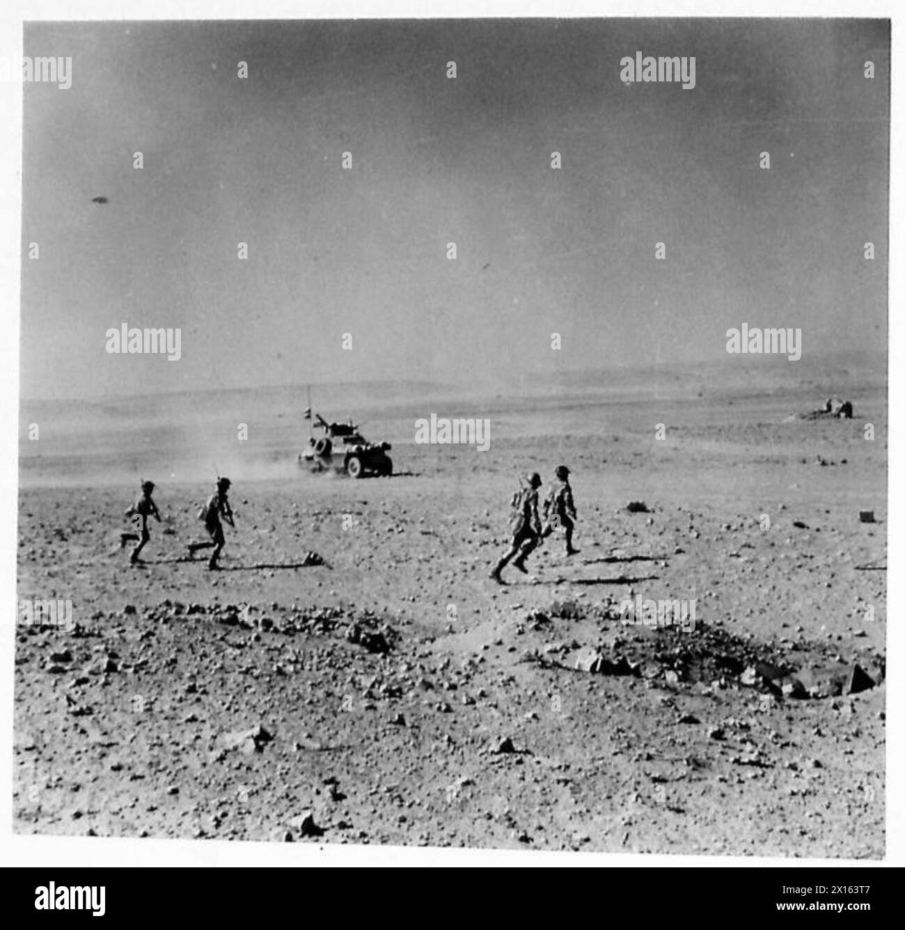 Infantry and armoured cars operate under bombing attack by enemy ...