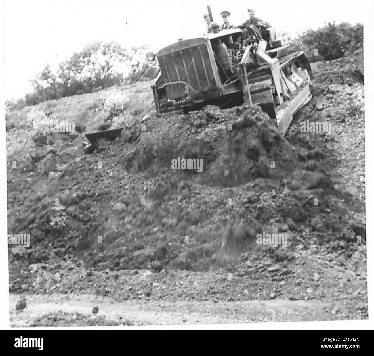 WAR CORRESPONDENTS VISIT ARMY TRACTOR SCHOOL - A BULLDOZER levelling ...