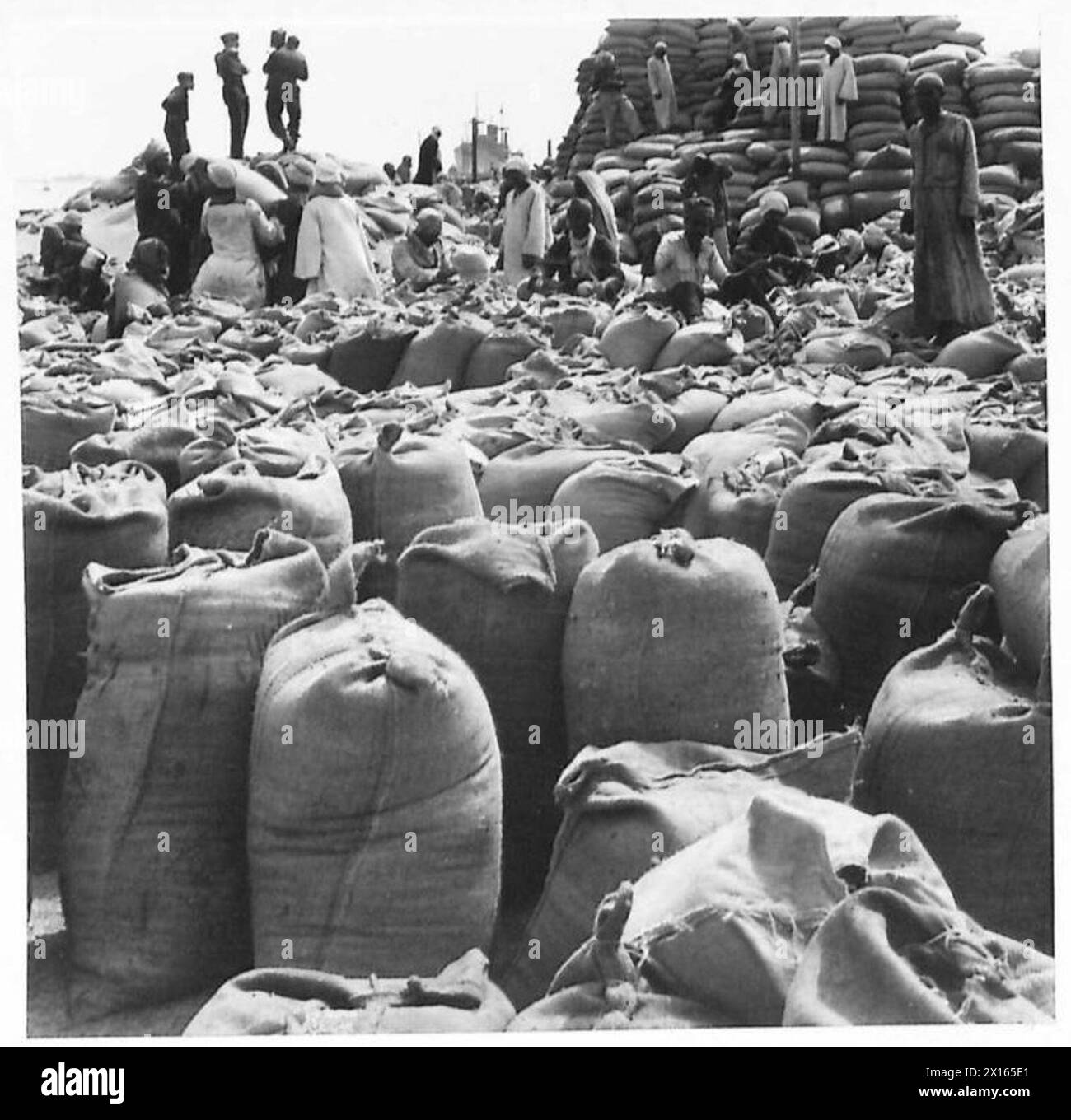 FOOD SUPPLIES FOR THE MIDDLE EAST - Natives stacking the sacks of wheat ...