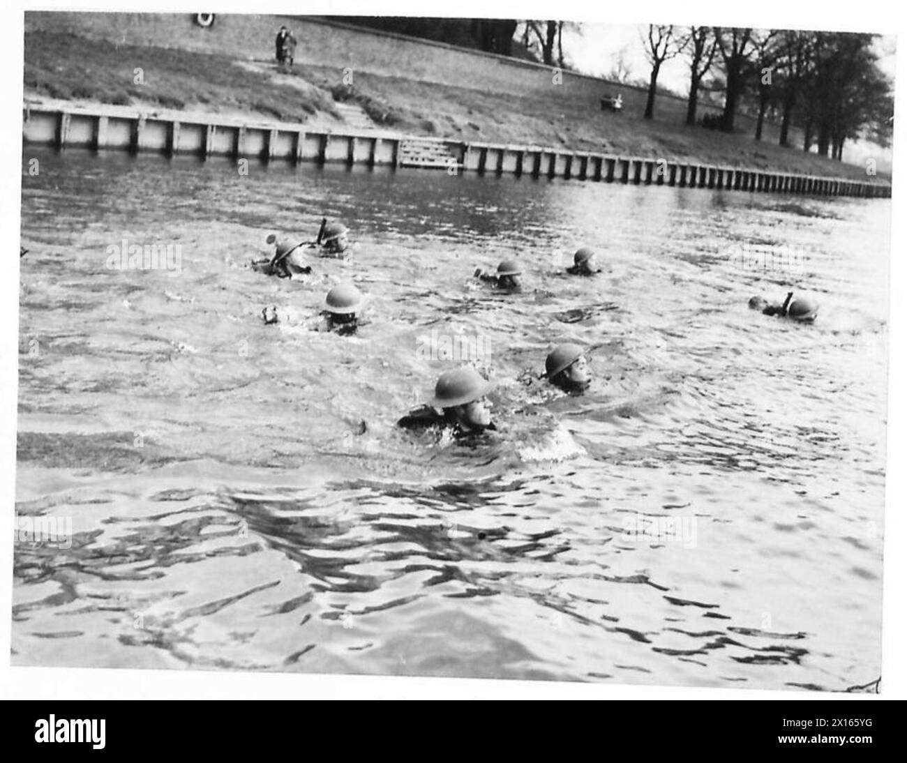 British Army soldiers swim across water as part of physical training to ...