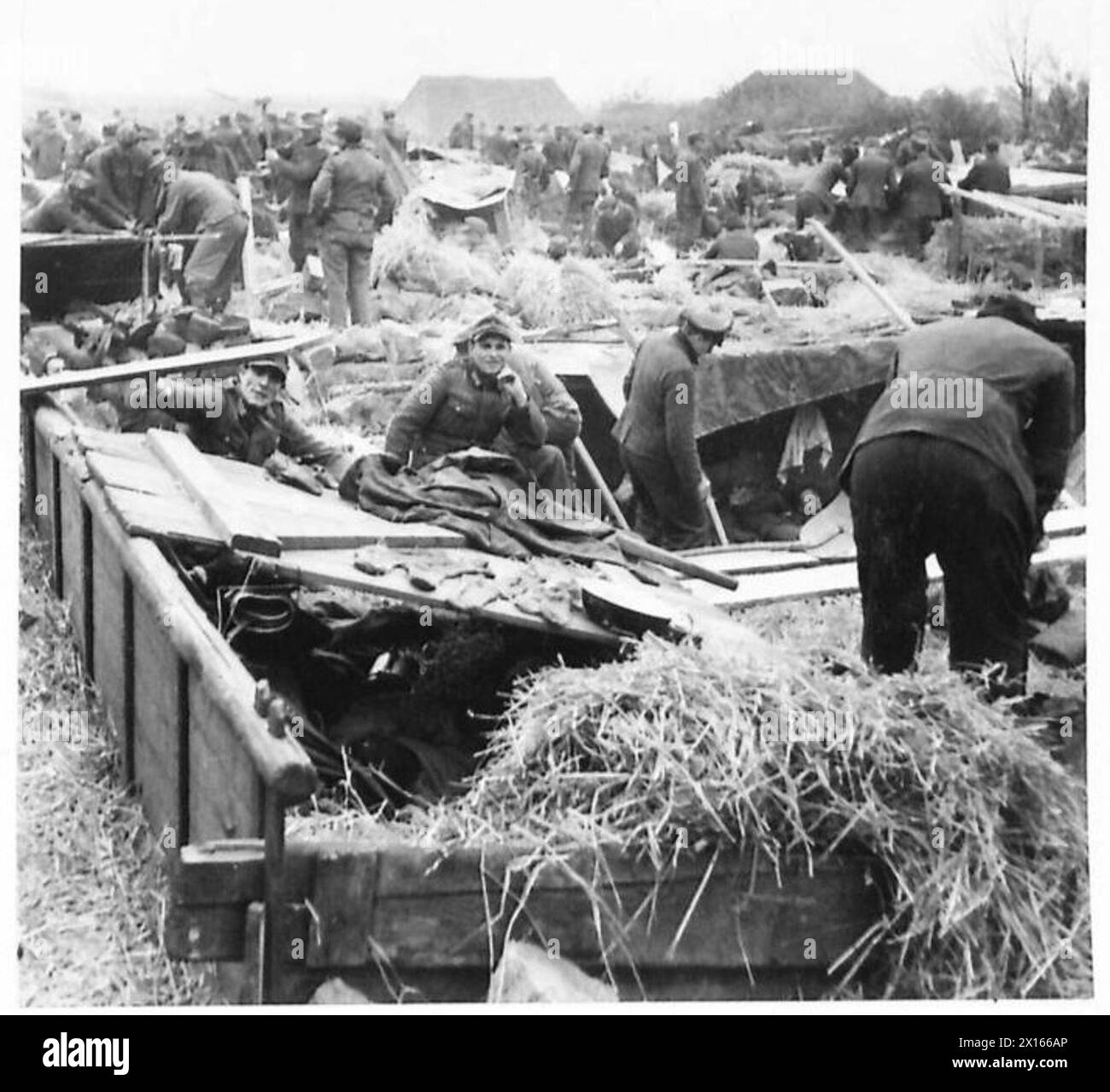 German prisoners of war in a Gadebusch camp construct a lean-to shelter ...
