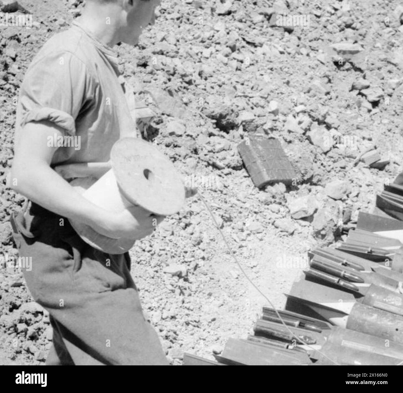 Two Royal Air Force Disarmament Wing members setting fuses on a pile of ...