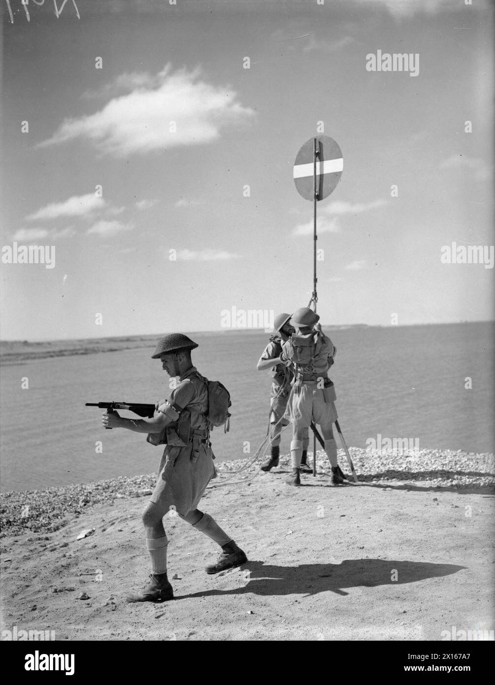 At HMS Saunders near Kabrit, Bitter Lakes, two men erected a beach sign ...