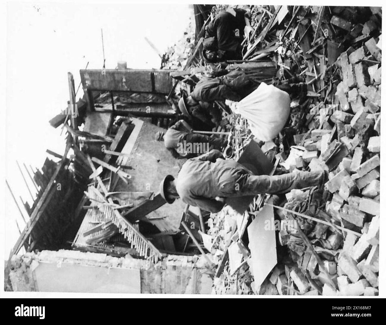 TROOPS HELP CLEAR UP AFTER AIR-RAID - Soldiers clearing away some of ...
