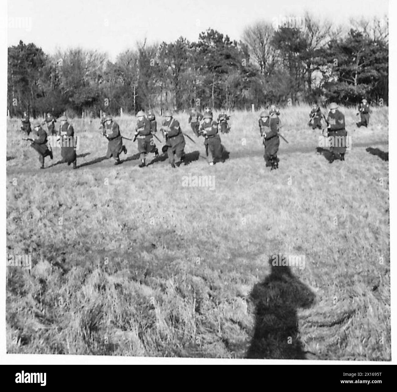 A Home Guard detachment advances across open ground during training ...