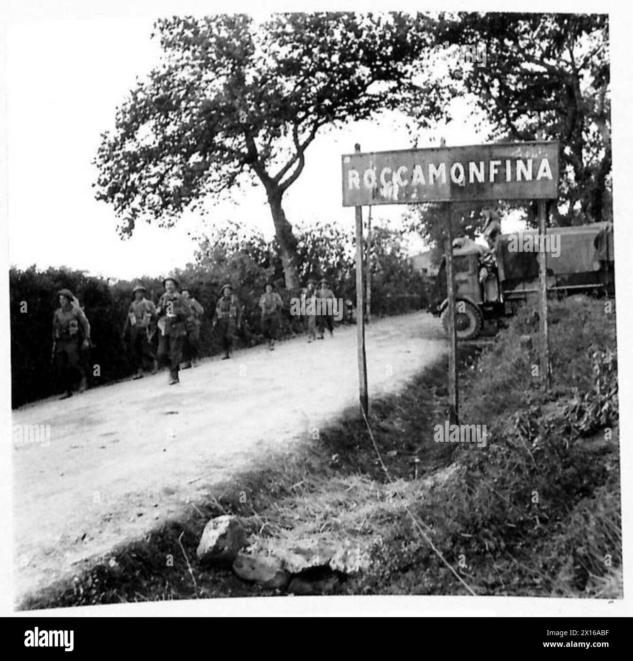 Soldiers of the 10th Royal Berkshire Regiment march past a road sign at ...