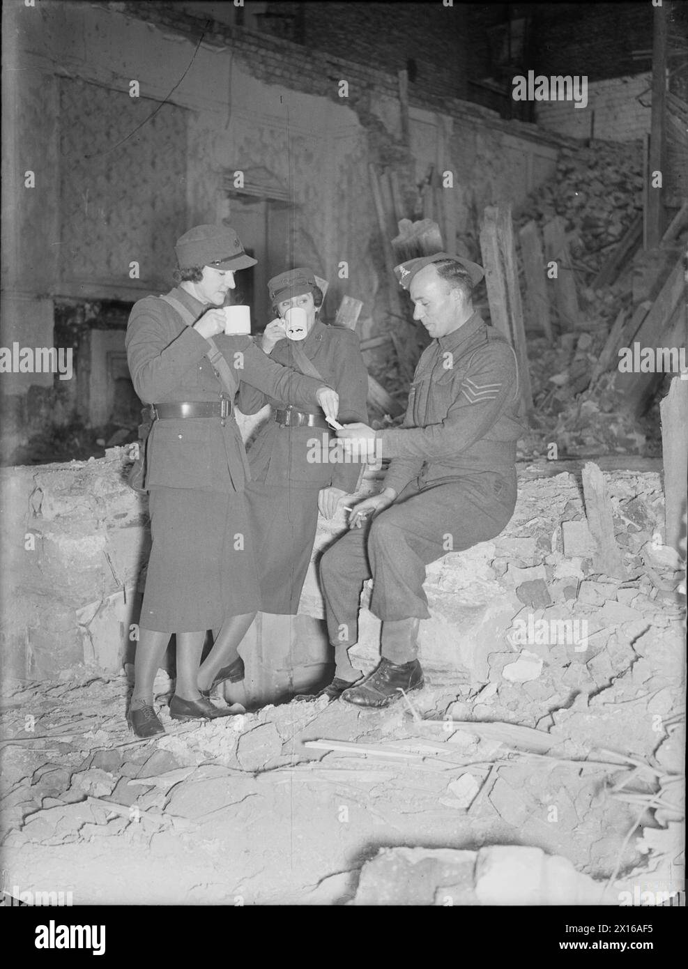 Women of the Mechanised Transport Corps in London, 1940, rest on rubble ...