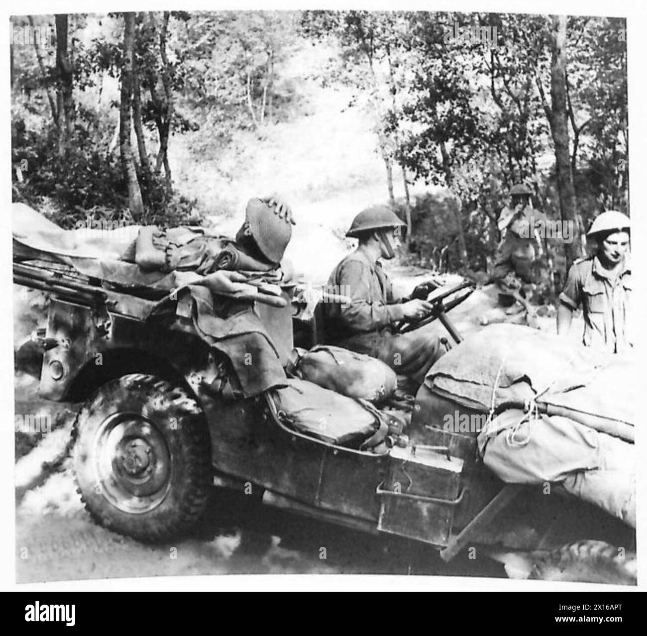 A wounded British soldier is secured on a stretcher lashed to a jeep ...