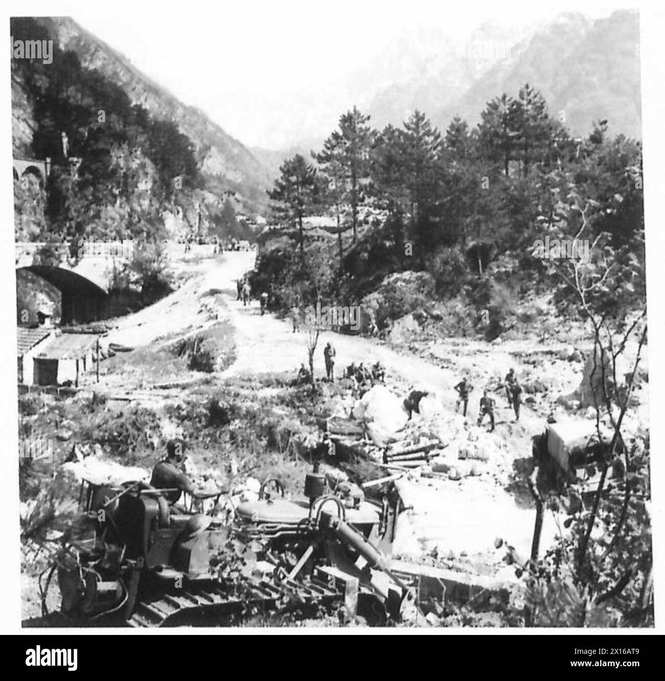 Bulldozers construct a diversion around a destroyed bridge on a route ...