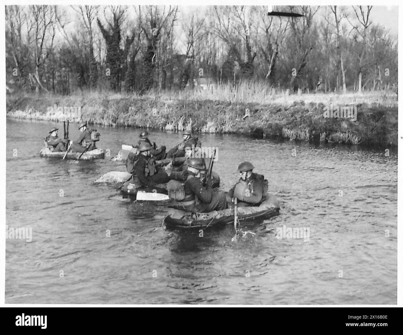 British Army troops are seen crossing a river using rubber boats ...