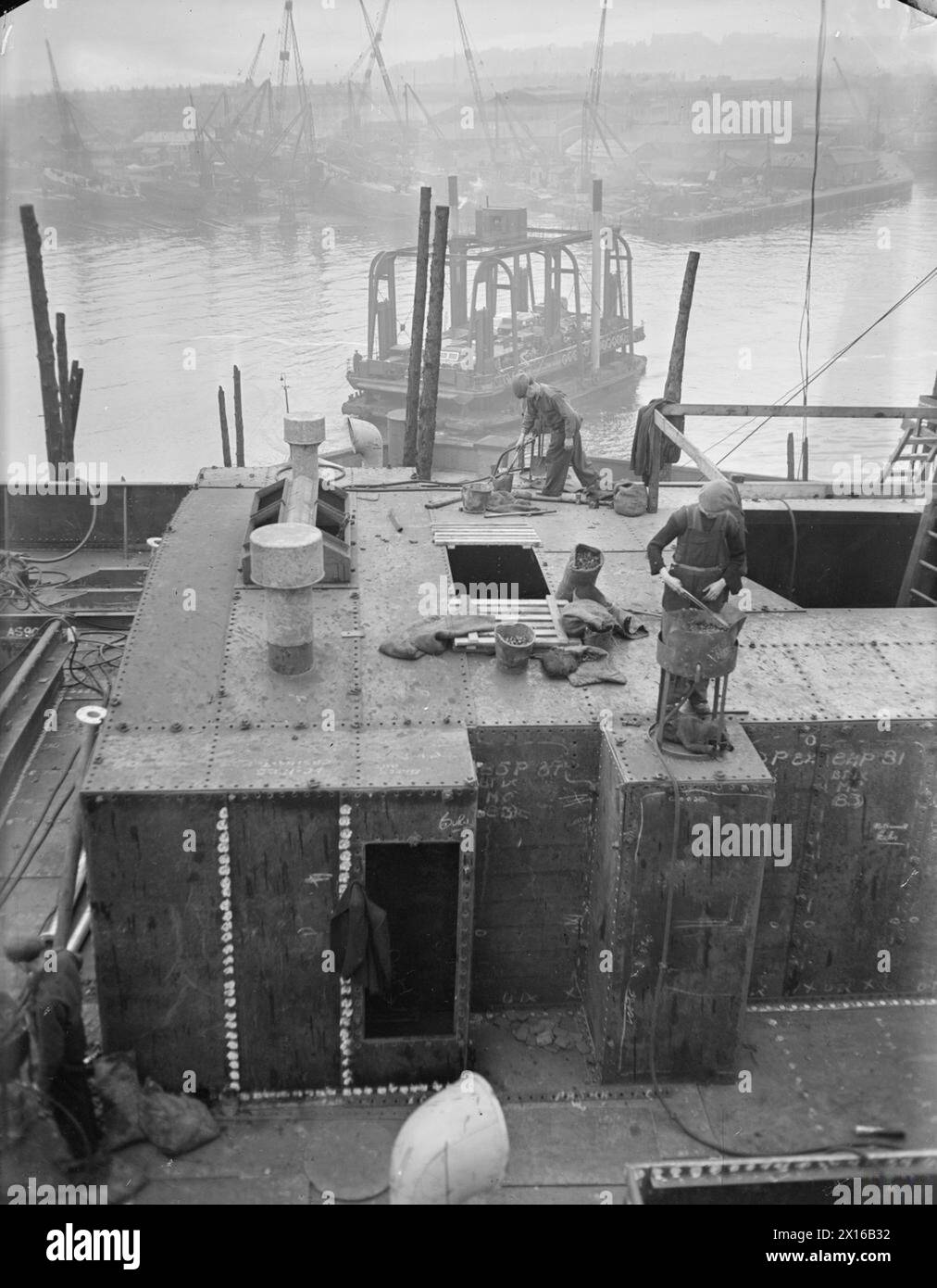 Men work on the deck superstructure of a merchant ship under ...