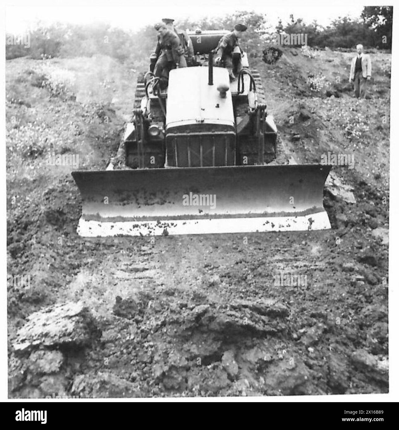 WAR CORRESPONDENTS VISIT ARMY TRACTOR SCHOOL - A BULLDOZER levelling ...
